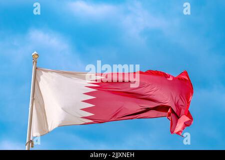 Qatar national flag waving in wind Stock Photo - Alamy