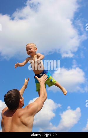 Father throws his laughing son in the air Stock Photo - Alamy