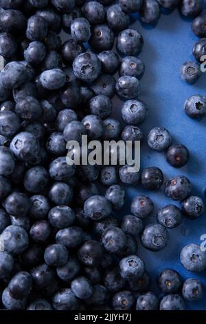 Vertical photo with scattered blueberries in a blue flat plate Stock ...