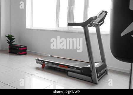 Modern treadmill near window in room, closeup Stock Photo - Alamy