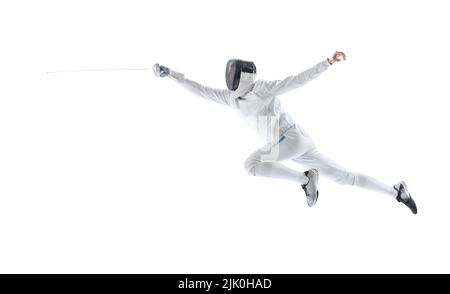 Dynamic portrait of young man, fencer in in fencing costume with sword ...