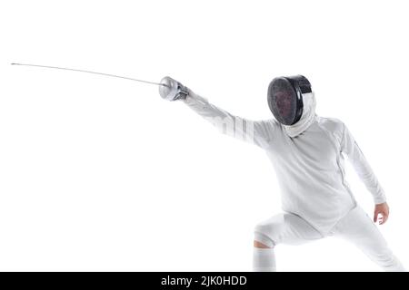 Dynamic portrait of young man, fencer in in fencing costume with sword ...