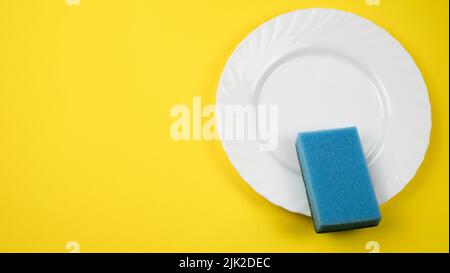 Cleaning sponge on white plate on gray background Stock Photo - Alamy