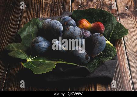 Figs in fig leaves on wooden table, top view Stock Photo - Alamy