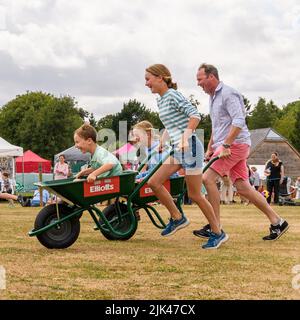 Competitors in a wheelbarrow race at the Damerham Fair and ...
