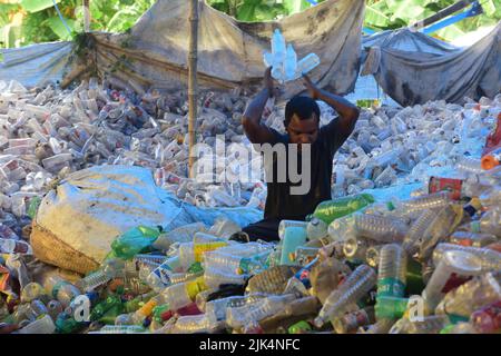 A man seen sorting plastic bottles at a workshop before sending them ...