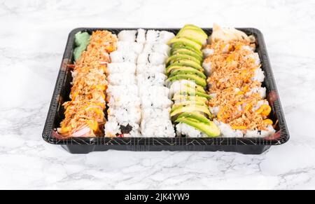 Pre-packaged variety of sushi and sushi rolls in a plastic tray Stock ...