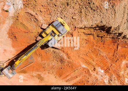 The excavator digs a pit for the connection of the storm sewer pipes ...