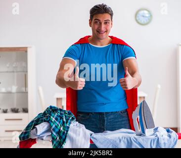 The super hero man husband ironing at home helping his wife Stock Photo ...