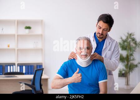 Old neck injured patient visiting young male doctor Stock Photo - Alamy