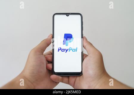 A hand holds smartphone shows PayPal logo Stock Photo - Alamy