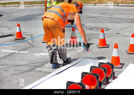 road workers with a road markings sprayer Stock Photo - Alamy
