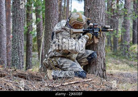 a human in the forest shoots from a machine gun Stock Photo - Alamy