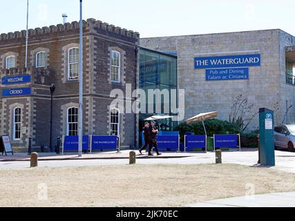 The Waterguard Public House, Cardiff Bay with man on electric ...