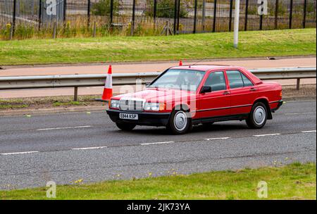 An August 1987- July 1988 red Mercedes Benz car motoring along the ...