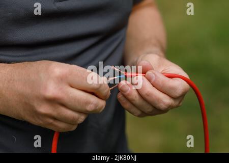 Hands connecting electrical wires together. Male hands and fingers ...