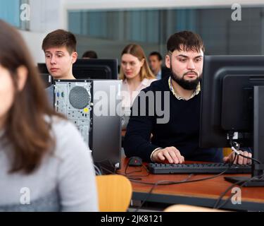Group of people of different ages learning to use computers in ...