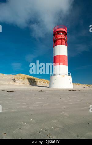 A vertical shot of the small lighthouse on the stones in water Stock ...