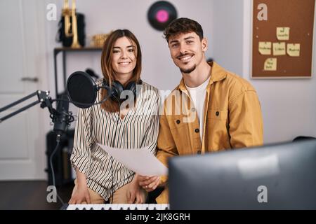 Mand and woman musicians singing song playing classical guitar at music ...