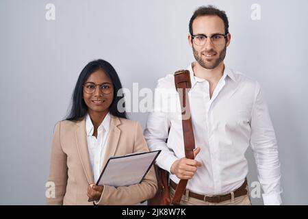 Interracial business couple wearing glasses with hand on chin thinking ...