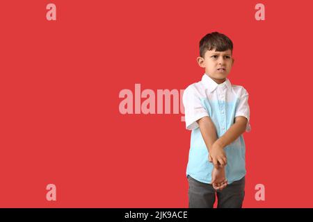 Little boy scratching himself on color background Stock Photo - Alamy