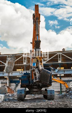 Excavator destroyer removes debris Building demolition Stock Photo - Alamy