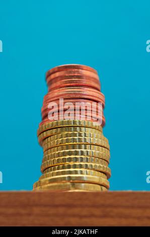 Euro coins piled up to a tower, closeup of euro currency. Blue ...