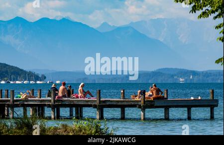 Berg Am Starnberger See, Germany. 01st Aug, 2022. Sun-seekers enjoy the ...
