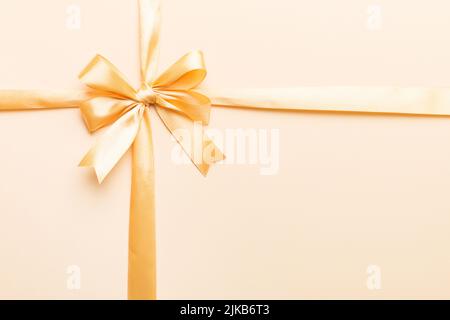 Top view of gold ribbon rolled and yellowbow isolated on colored ...