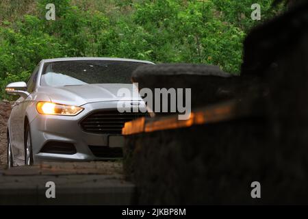 Armenia - July 22, 2022: Half visible Ford Fusion behind a stone ...