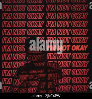 A projector photography with red 'I'm not okay' text and human shadow ...