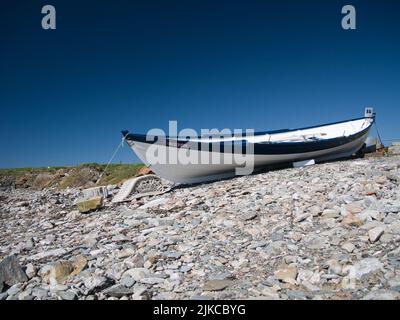 A small clinker built wooden rowing boat and modern fibreglass type ...