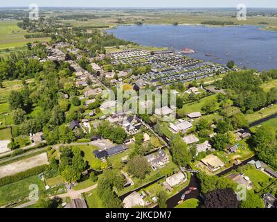 An Aerial shot of Giethoorn village with houses and green trees in a ...