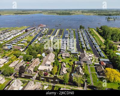An Aerial shot of Giethoorn village with houses and green trees in a ...