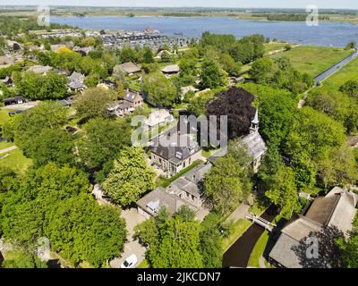 An Aerial shot of Giethoorn village with houses and green trees in a ...