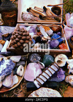 A vertical shot of crystal stones, palo santo, and smudge sticks for ...