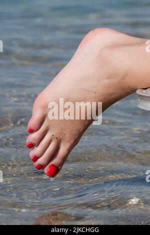 Woman's foot with red nails, Aghia Triada beach, Thessaloniki Bay ...