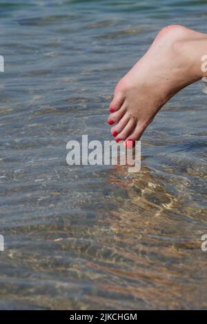 Woman's foot with red nails, Aghia Triada beach, Thessaloniki Bay ...