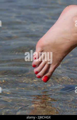 Woman's foot with red nails, Aghia Triada beach, Thessaloniki Bay ...