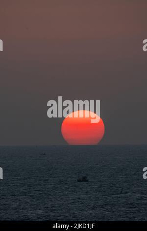 A vertical shot of a beautiful mirage sunset on the sea Stock Photo - Alamy