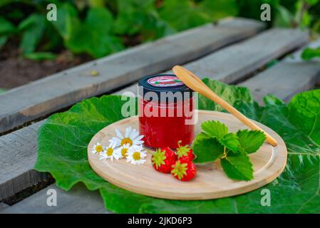 a jar of strawberry jam stands on a board Stock Photo - Alamy