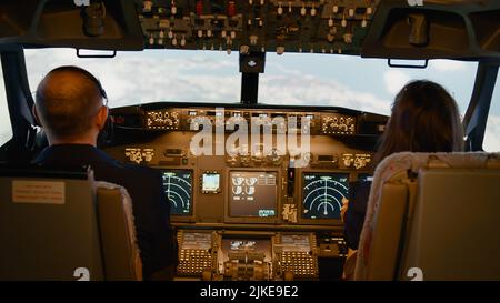 Plane captain and woman copilot fixing altitude on dashboard, using ...