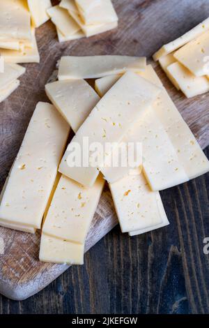 cut into pieces real hard cheese with lots of milk, the product of milk ...