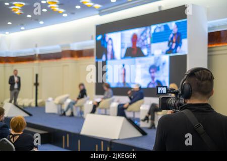 Cameraman shooting stage during business seminar Stock Photo - Alamy