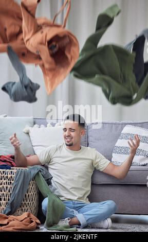 Young hispanic man washing clothes looking t shirt label at laundry ...