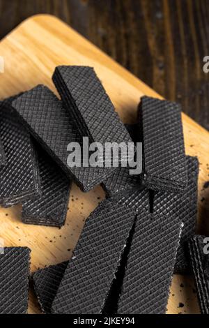 sweet dessert black waffles with creamy filling inside, laid out on a ...