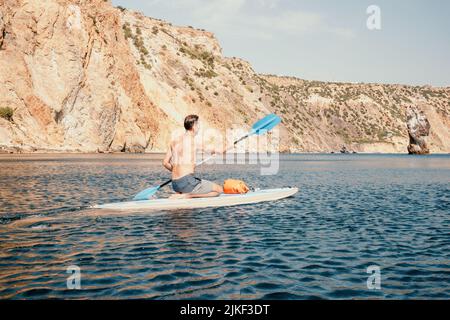 Side view foto of a man swiming and relaxing on the sup board. Sportive ...