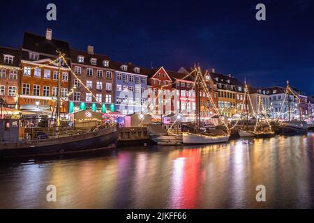Copenhagen skyline reflections on Nyhavn street at night in Denmark ...