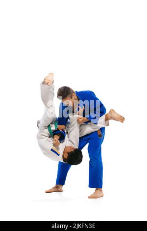 Portrait of two professional judo athletes training, fighting isolated ...