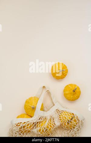 Yellow round small pumpkins in an eco friendly mesh bag and fallen ...